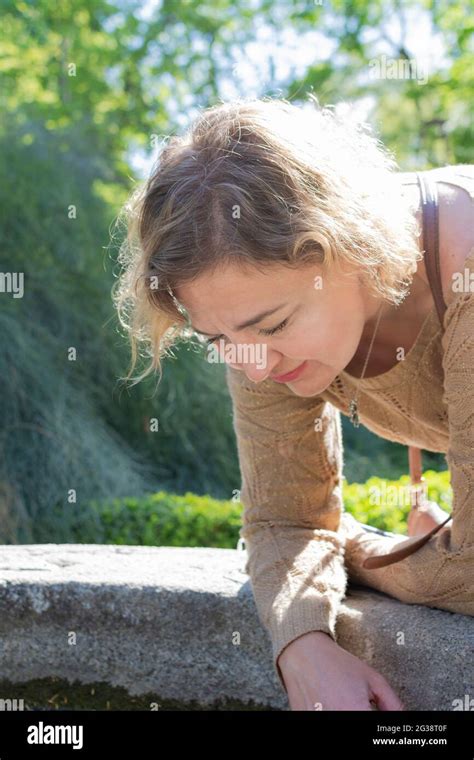 Beautiful Middle Aged Blonde Woman Bent Over And Leaning With Her