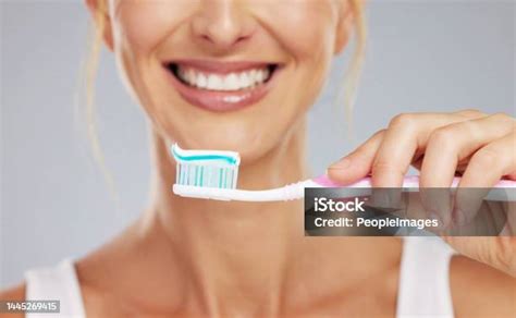 아침에 치약 손 칫솔은 모형 스튜디오 배경에서 깨끗한 치아 건강 및 치과 건강 관리로 미소를 짓습니다 입 청소 미용 미용 및 건강한 자기 관리 루틴의 확대 40 44세에