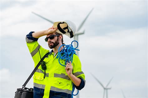 눈에 잘 띄는 옷을 입은 작업자가 흐린 날 풍력 터빈 근처에서 헬멧을 조정합니다 가구에 대한 스톡 사진 및 기타 이미지 가구 가수 거실 Istock