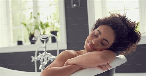 고요한 곱슬 여성은 자유 시간을 즐기고 목욕을 하면서 기쁨으로 눈을 감고 있다 사진 Unsplash의 여성 이미지