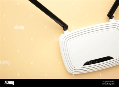 White Wi Fi Router With Black Antennas On Beige Background With Copy