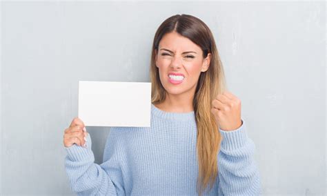 통해 회색 그런 지 벽 잡고 빈 카드 화가 젊은 성인 여자와 미친과 제기 손으로 소리 분노와 좌절 외치고 분노 개념 갈색 머리에