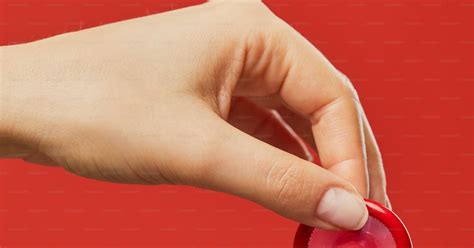 빨간 배경에 콘돔을 들고 있는 여성의 손의 생생한 근접 촬영 안전한 섹스와 보호 개념 사진 Unsplash의 Aids 이미지