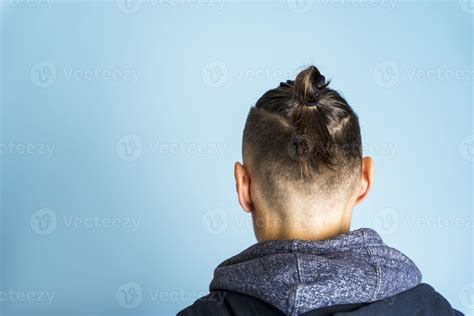 A Man With A Hairstyle Top Knot Or A Mans Bun On A Blue Background Mens Hairstyles Hair Care