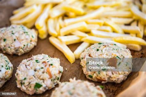 전통적인 해산물 식사로 요리하기 전에 오븐용 베이킹 트레이 양피지에 냉동 프렌치 칩 프라이 생 생선 게 케이크의 매크로 근접 촬영 어묵에 대한 스톡 사진 및 기타 이미지