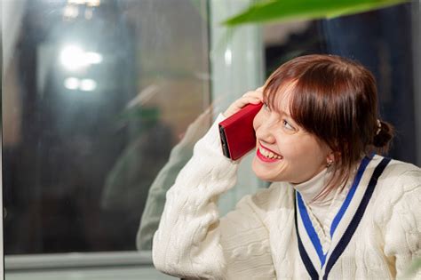 그녀의 손에 스마트 폰과 흰색 스웨터에 예쁜 소녀는 창가에 의해 집의 창턱에 앉아 30 34세에 대한 스톡 사진 및 기타 이미지 30 34세 가정 생활 가정의 방