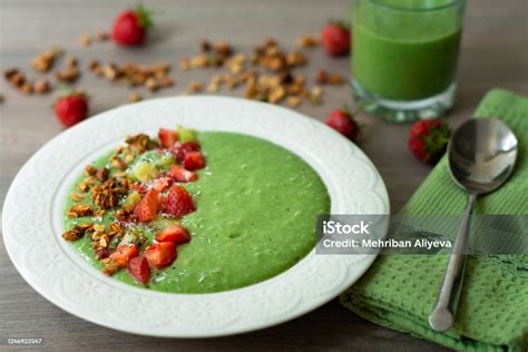 바나나 딸기 시금치 케일 키위 코코넛 밀크를 수제 귀리 견과류 씨앗 그래놀라 코코넛 플레이크 치아 씨 키위 딸기로 장식한 그린 스무디 볼 0명에 대한 스톡 사진 및 기타