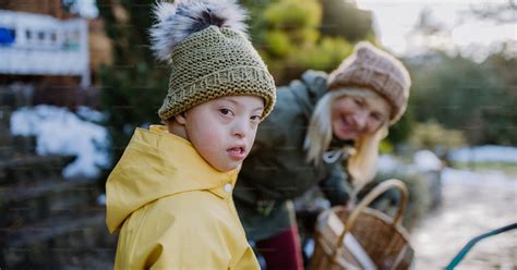 다운 증후군을 앓고있는 소년은 카메라를보고 할머니와 함께 겨울에 정원에서 일합니다 사진 Unsplash의 슬로바키아 이미지