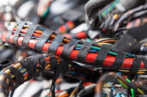 차량 내 전기 및 디지털 신호를 연결하고 전송하기 위한 배선 수리점 및 전기 기술자의 여러 가지 색상의 주황색 및 녹색 전선 커넥터 및 터미널이 있는 대형 와이드 케이블