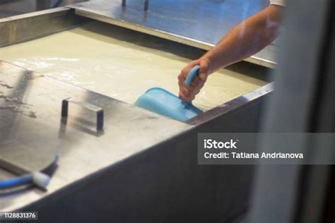 공장 우유에서 치즈를 만드는 기술 Aceptic 방 남자의 손에 믹스 및 거 대 한 금속 통에 큰 터너 요리사 치즈의 유리를