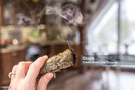 건조 세이 지 스머지 스틱 흡연의 여자 손 들고 허브 번들 그것은 부정적인 에너지를 정화 하 고 객실에서 집에서 생활 공간을 정화 하는 것으로 추정 된다 가정 생활에 대한