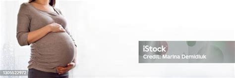 창에 큰 배를 가진 임산부 출산 전 관리 및 여성 임신 개념 젊은 임산부는 부어 오른 배에 손을 얹고 있다 사랑 개념 수평 복사 공간 가냘픈에 대한 스톡 사진 및 기타