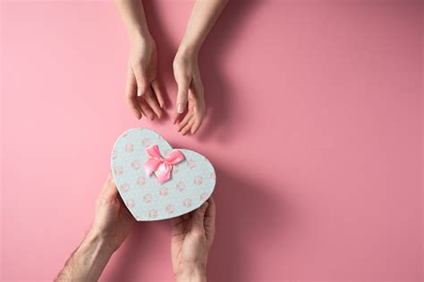 발렌타인 데이 축하 개념입니다 사랑하는 사람의 좋은 선물 섬세한 분홍색 배경에 남자와 여자의 활 손이 상자 공간을 복사합니다 플랫 레이 2월에 대한 스톡 사진 및 기타