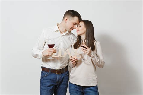 젊은 백인 커플 행복 한 남자와 여자 캐주얼 빛 옷에 사랑에 웃 고 붉은 안경에서 마시는 토스트 만드는 청바지에 고립 된 흰색 배경 와인 광고에 대 한 공간을 복사 합니다