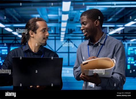 Smiling Manager Inspecting Server Room Equipment Reading Paperwork