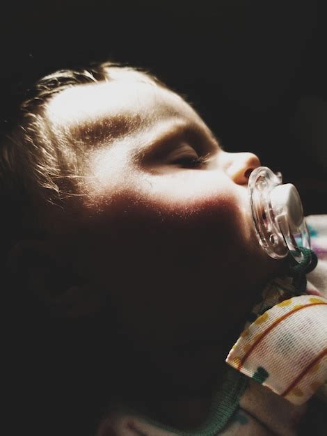 Premium Photo Close Up Of Cute Girl Sucking Pacifier Against Black