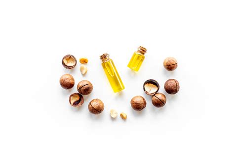 마카다미아 너트 오일은 견과류를 곁들인 유리 병에 담겨 있습니다 식품 또는 화장품에 대한 에센스 엑스트라 버진 오일 건강관리와 의술에 대한 스톡 사진 및 기타 이미지