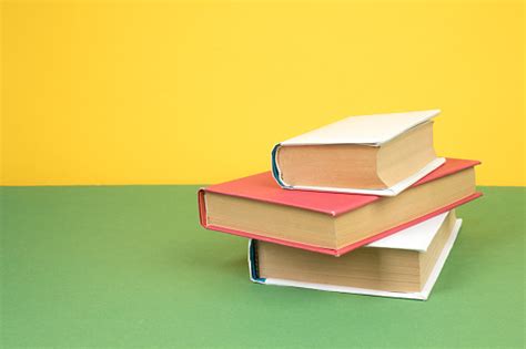 책 쌓기 나무 테이블과 녹색 배경에 하드 백 책을 엽니 다 학교로 돌아 가기 광고 텍스트의 공간을 복사합니다 더미에 대한 스톡 사진 및 기타 이미지 Istock