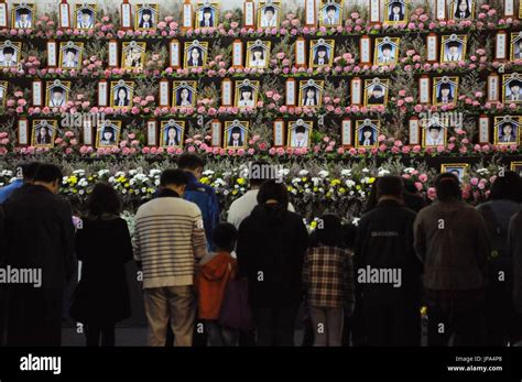 Citizens Observe A Silent Prayer Before Pictures Of The Victims Killed