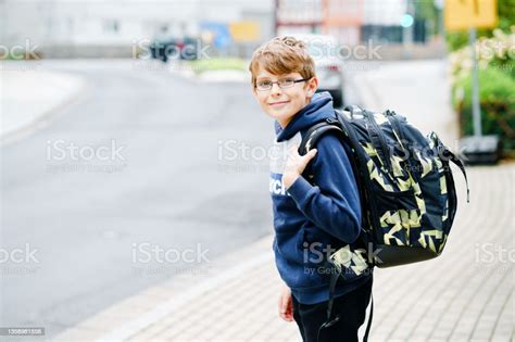 가방과 안경을 가진 행복한 어린 아이 소년 중학교 나 고등학교로 가는 길에 안경을 쓰고 있는 학교 키드 학교 마당에서 야외에서 흥분 한 아이 학교로 돌아갑니다 8월에 대한