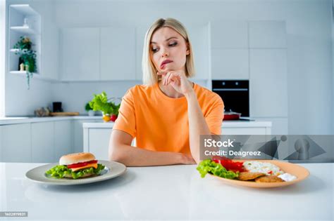 입술을 물어뜯는 마음 속의 사진 딜레마 따기 쌀 고기 야채 버거 패스트 푸드 플랫 현대 부엌 실내 20 24세에 대한 스톡 사진