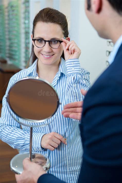 Woman With Mirror Trying On New Glasses In Optic Stock Image Image Of