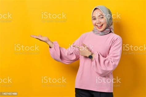 노란색 배경에 손바닥에 복사 공간을 보여주는 분홍색 셔츠를 입은 젊은 아시아 여성 20 24세에 대한 스톡 사진 및 기타 이미지 20 24세 광고 긍정적인 감정 표현