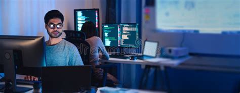 Asian Software Developers Working On Multiple Screens Displaying Code And Application Diagrams