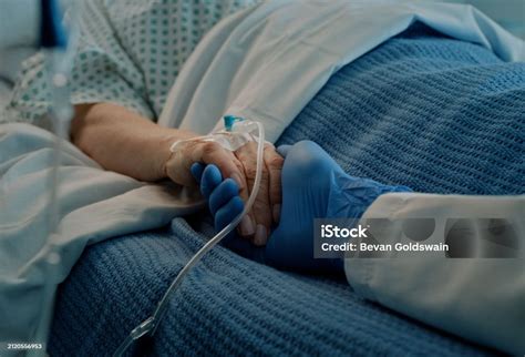 병원 의사와 손을 잡고 침대에 누워 수술 후 클리닉에서 함께 지원하고 돌봅니다 노인 의료 및 암 환자는 공감 친절 연민을 가지고 도움을 주는 간병인입니다 병원에 대한 스톡