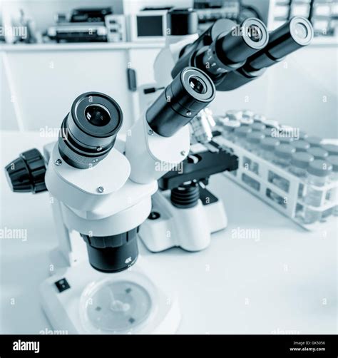Science Microscope On Lab Bench Microbiology Laboratory Blue Toned Image Of Binocular