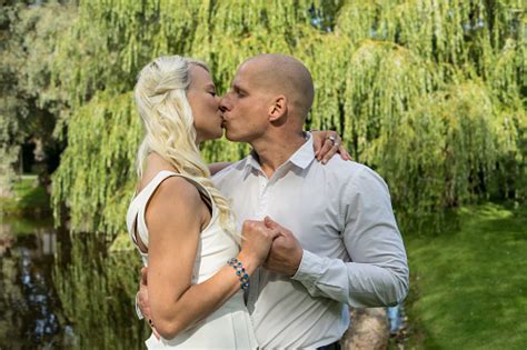 행복 한 커플입니다 신랑 신부를 포옹 하 고 키스 사랑에 빠진 남녀 공원 녹색 자연 배경에서에서 휴식 하는 젊은 이들이 2명에