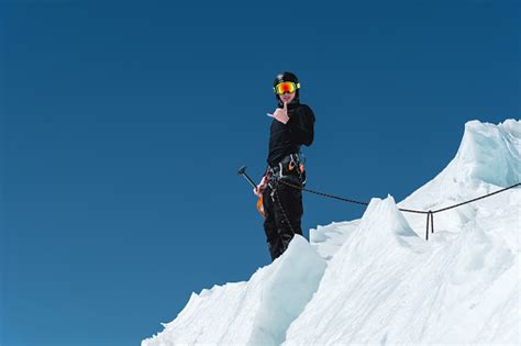 한 산악인 빙하의 가장자리에 그의 손에서 눈 삽으로 서 나타나고 떨의 제스처 푸른 하늘에 대 한 겨울 코트에 대한 스톡 사진 및 기타 이미지 Istock