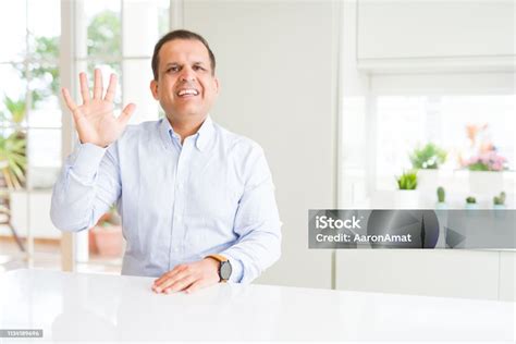 집에 앉아있는 중 노년 남자는 자신감을가지고 행복 하 게 웃는 동안 다섯 손가락 숫자를 표시 하 고 가리키는 가리키기에 대한 스톡 사진 및 기타 이미지 Istock