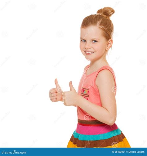 Счастливая радостная маленькая девочка усмехаясь показывающ большие пальцы руки вверх