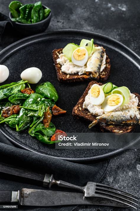 정어리 계란 오이 크림 치즈를 곁들인 샌드위치 시금치와 말린 토마토를 곁들인 샐러드 장식 검은 색 배경입니다 맨 위 보기 0명에 대한 스톡 사진 및 기타 이미지 Istock
