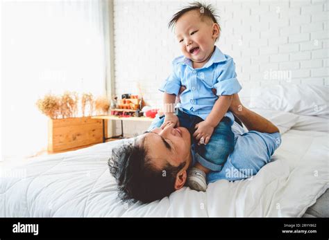 Deux Père Asiatique Et Son Fils Sont Couchés Et Jouent Dans Le Lit à La