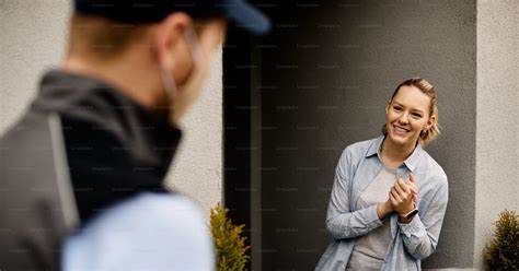 출입구에 서서 피자 상자를 들고 있는 배달원을 맞이하는 행복한 여자 사진 Unsplash의 공급망 이미지