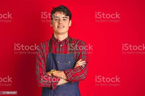 고립된 배경 위에 직원 앞치마를 입은 십대 소년은 카메라를 보고 교차 된 팔로 미소 짓는 행복한 얼굴입니다 긍정적 인 사람 비즈니스에 대한 스톡 사진 및 기타 이미지
