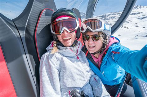 스위스에서 스키 리프트에서 Selfie를 복용 하는 두 젊은 여성이 스키 두 여자 관광 스위스 알프스와 휴가 개념의 휴일 공중 케이블 카에 대한 스톡 사진 및 기타 이미지