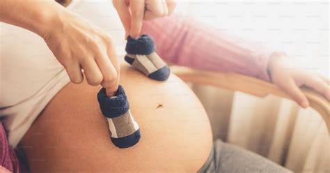 남편과 아내의 임신 한 부부는 집에서 사랑을 느끼고 휴식을 취합니다 젊은 기대하는 여자는 임신한 배에 아기를 안고 있다