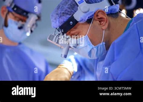 Surgeons In Complex Operation Two Surgeons Focus Intently On A Complex