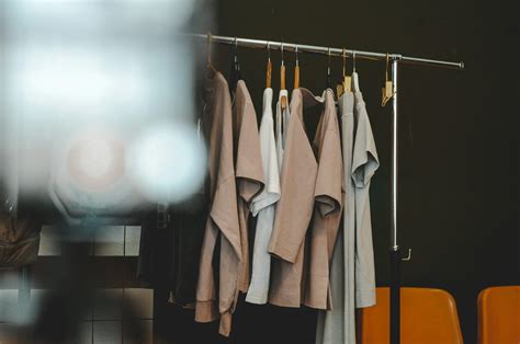옷은 미니멀리스트 스타일로 선반에 걸려 있습니다 사진 Unsplash의 무료 포토세션 이미지