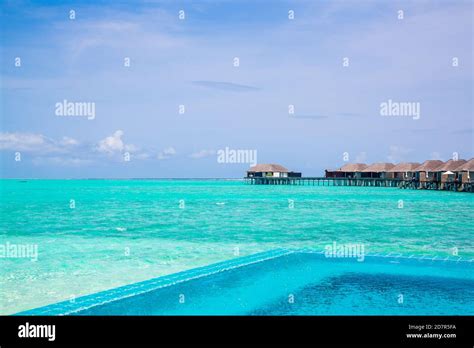 Long Empty Jetty In The Maldives With Coral Reefs In The Water Stock
