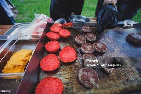다른 멀티 요리 과정 컬러 야외 축제 나무 책상 난로에 다양 한 충전 재 및 재료와 검은 장갑에 요리사의 보기에 햄버거 건강에