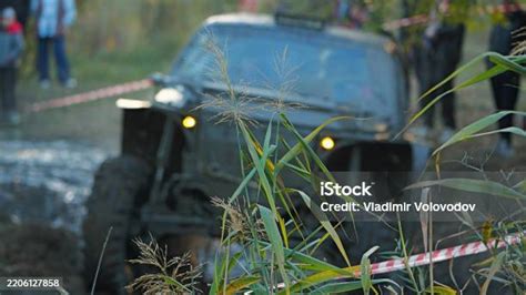 푸른 잔디를 배경으로 오프로드 차량이 대회 중 진흙 투성이의 트랙을 따라 거칠게 주행하는 모습이 보입니다 익스트림 머드 레이싱 0명에 대한 스톡 사진 및 기타 이미지
