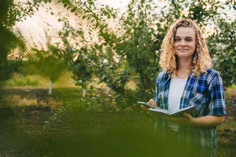 야채 성장 체크리스트 농업 사업 개발 및 초상화를 가진 컬리 머리 여성 농업 정원 가꾸기 지속 가능성 담당자는 검사를 위한 포트폴리오를 가지고 카메라를 바라보며 미소를 짓고