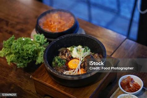 돌소트 비빔밥 한국식 혼합 쌀 찐 쌀 야채 돼지고기 계란 후라이를 얹은 후 뜨거운 돌 냄비에 담아 서빙합니다 쌀 주식에 대한