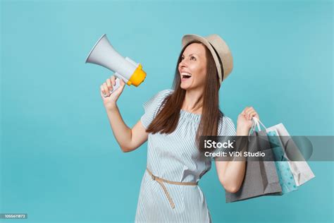 여름 드레스에 세로 여자 모자 패키지 가방을 들고 블루 파스텔 배경에 고립 된 할인 판매 발표 구매 후 쇼핑 확성기에서 비명 광고에 대 한 공간을 복사 합니다 가방에 대한