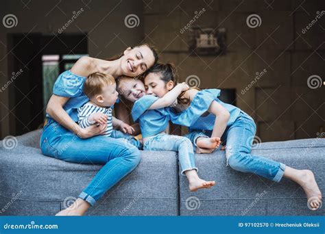 Мама 2 дочери и маленького сын на кресле Стоковое Фото изображение насчитывающей женщина