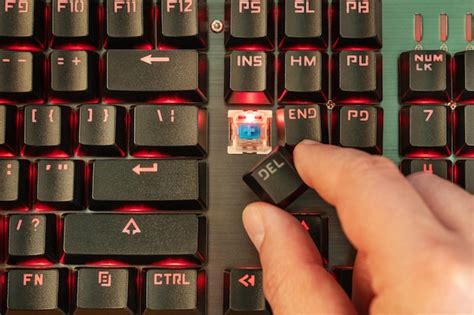 Premium Photo Male Hand Holds Delete Button Over Broken Red Backlit Keyboard